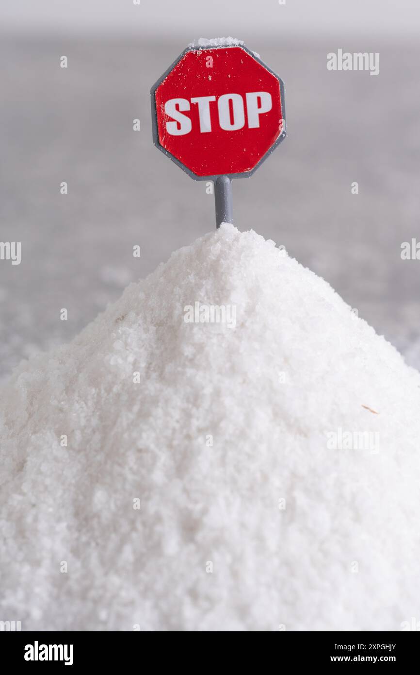 Stop sign on pile salt. Conceptual image stop salt Stock Photo - Alamy