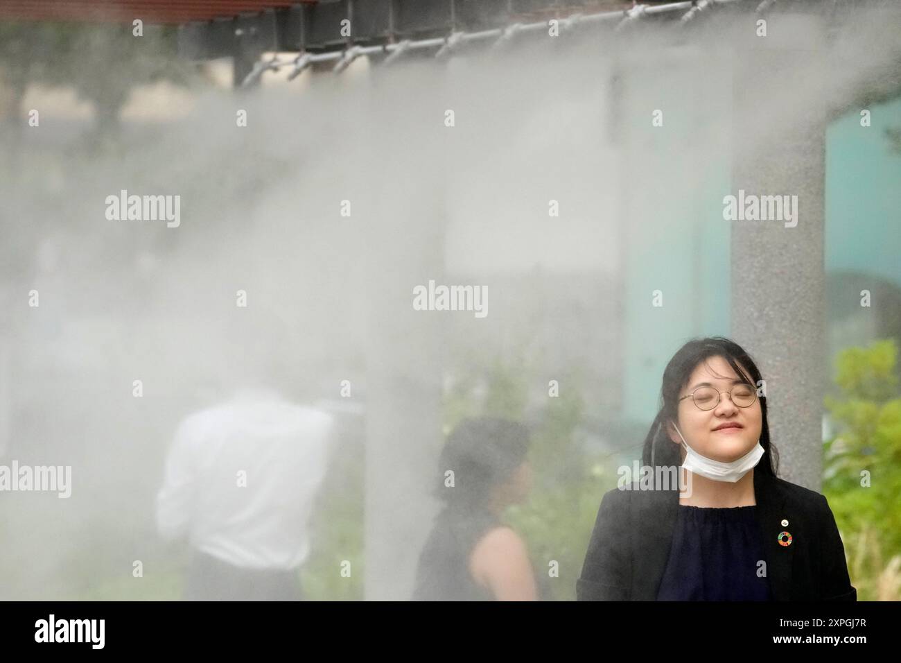 FILE - People cool off at a cooling mist spot on July 4, 2024, in Tokyo ...