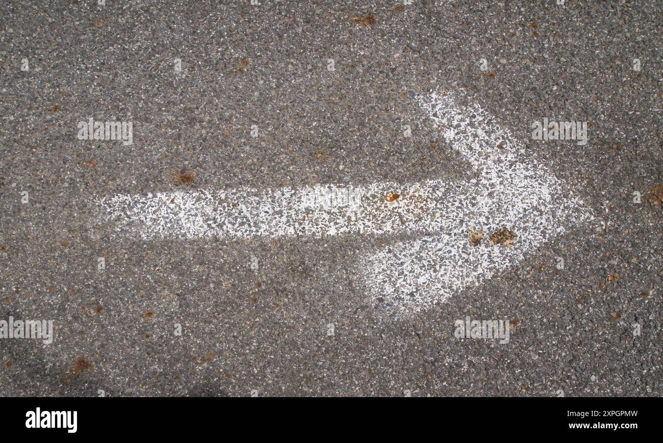 Transport traffic sign white arrow on the grey road Stock Photo - Alamy