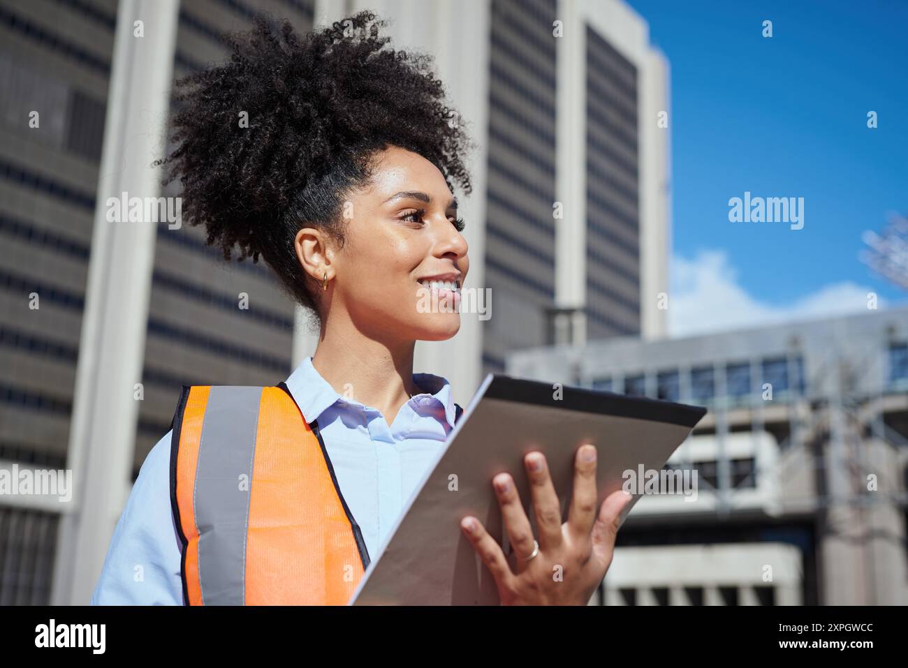 Confident Female Construction Worker Holding Clipboard in Urban Setting ...