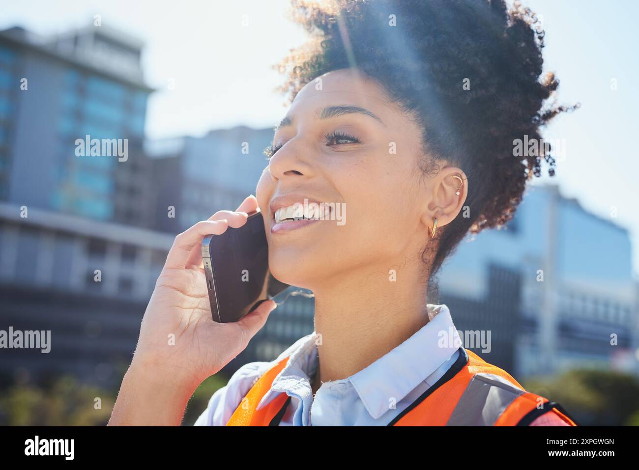 Smiling Construction Worker on Phone Call in Cityscape Stock Photo - Alamy