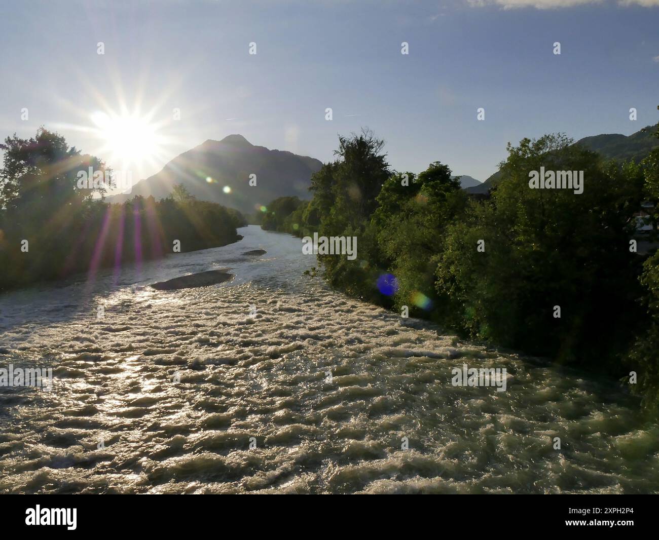 sunset over the river in Haute Savoie in Cluses. Sun flare above Arve ...
