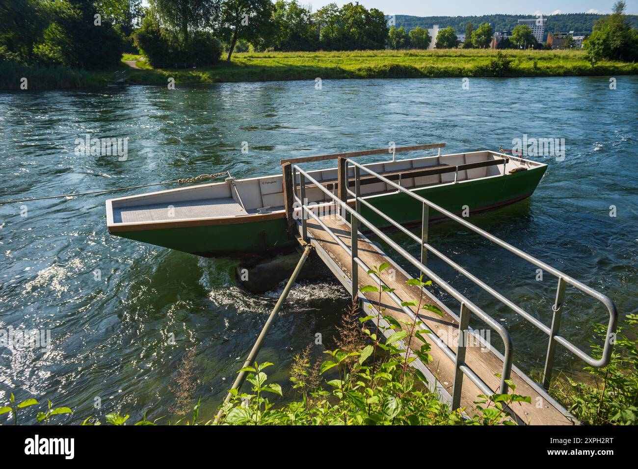 Small empty wooden reaction ferry on a river bank in Europe. Sunny ...