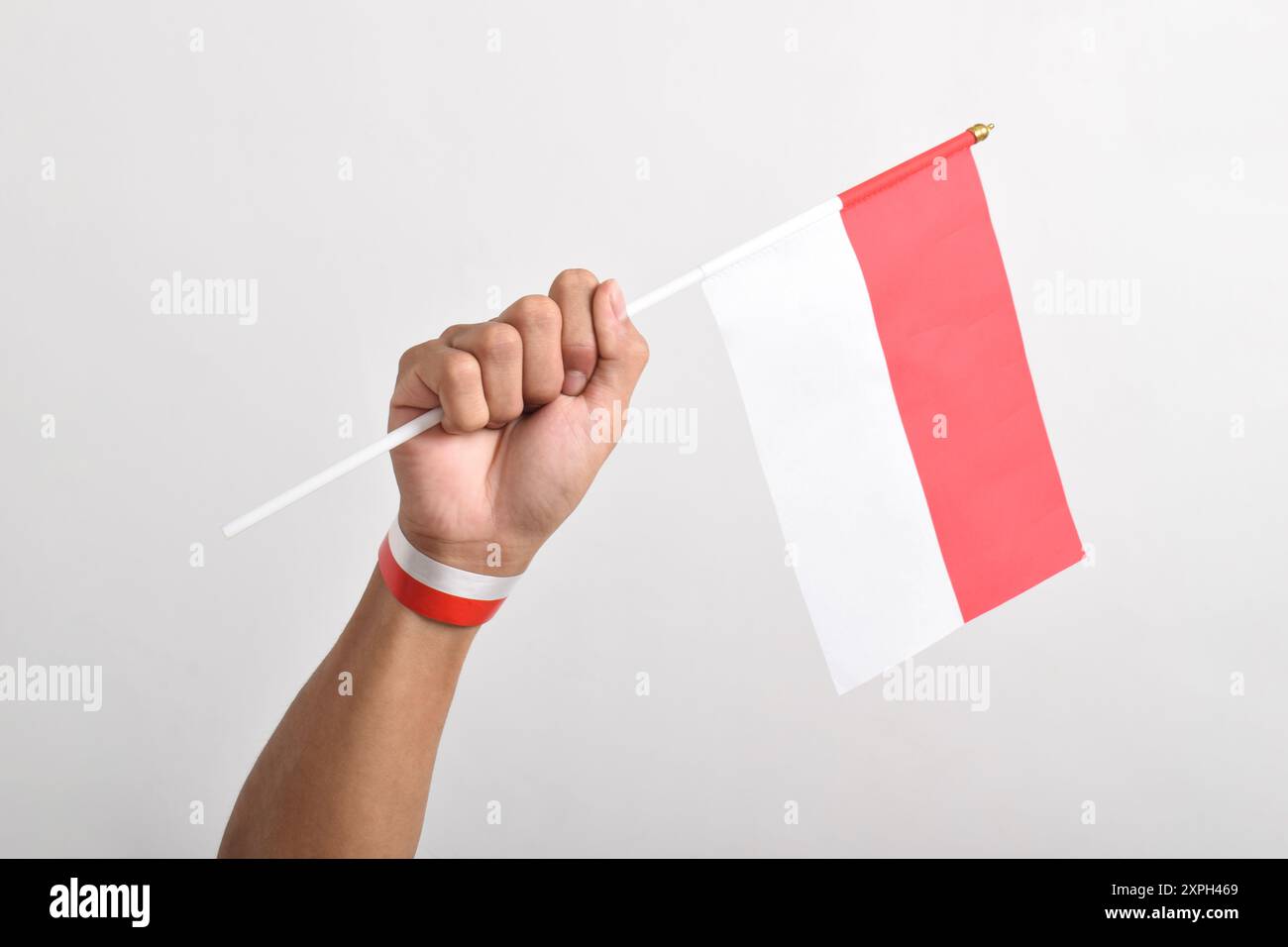 Human hand holding an Indonesian flag isolated on white background ...