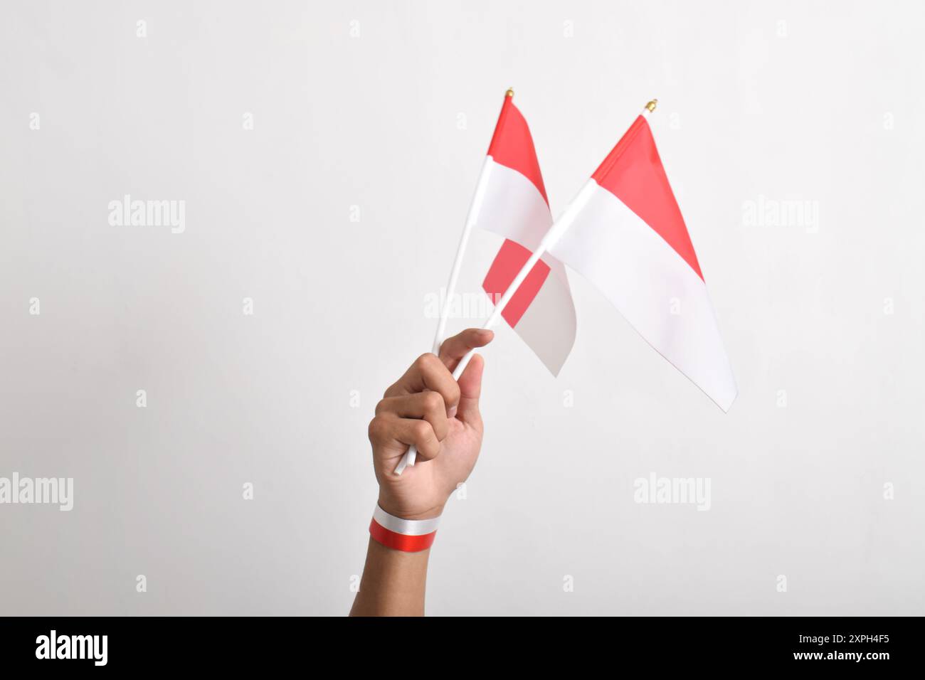 Human hand holding an Indonesian flag isolated on white background ...