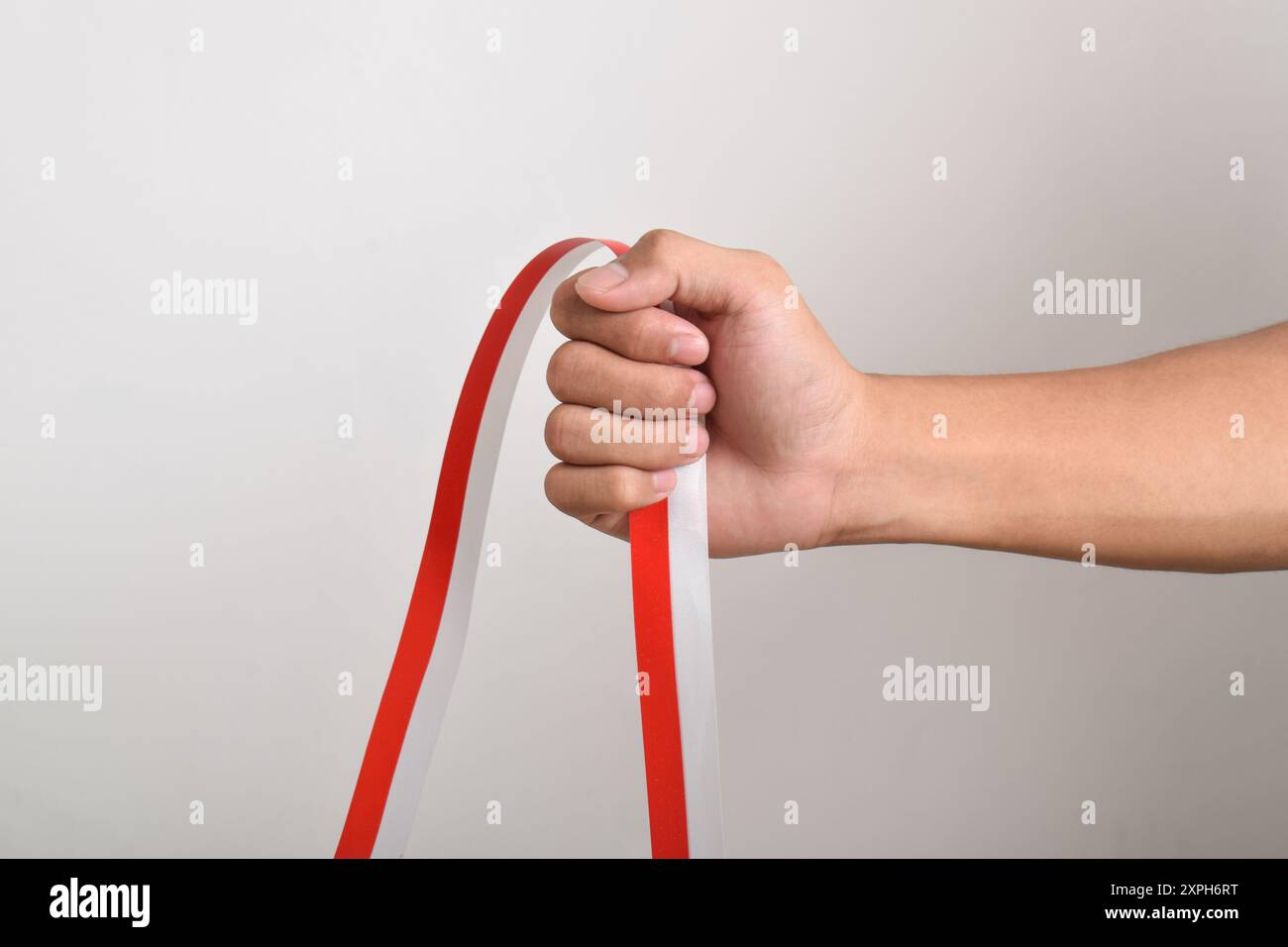 Hands clench with red and white ribbons as a symbol of the Indonesian ...