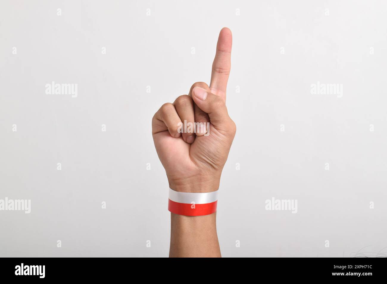 Man's hand pointing one finger with red and white ribbon as symbol of ...