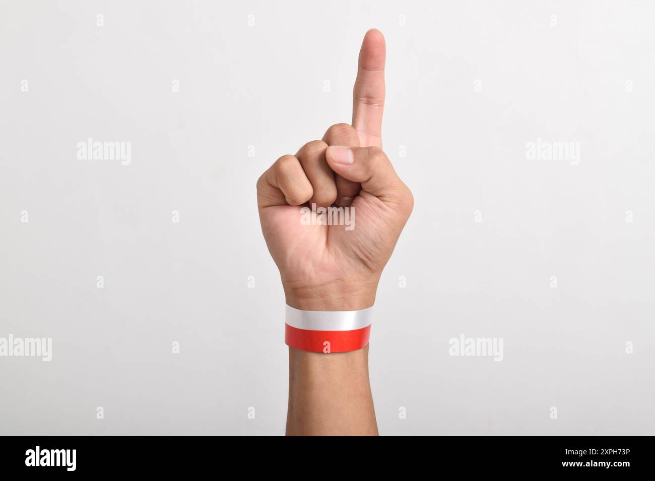 Man's hand pointing one finger with red and white ribbon as symbol of ...