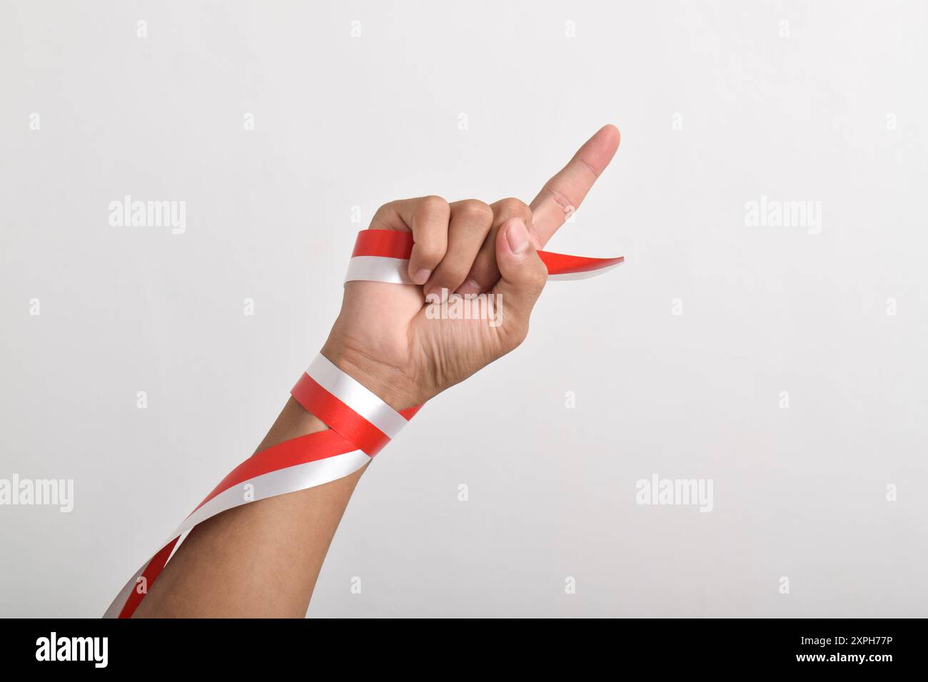 Man's hand pointing one finger with red and white ribbon as symbol of ...