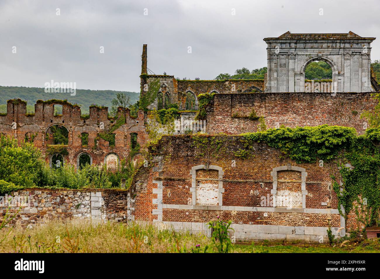 Ruins of ancient Aulne Abbey, brick walls covered with climbing plants ...