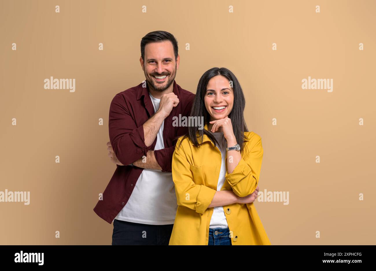 Charming young man and woman with hands on chins smiling and looking at ...