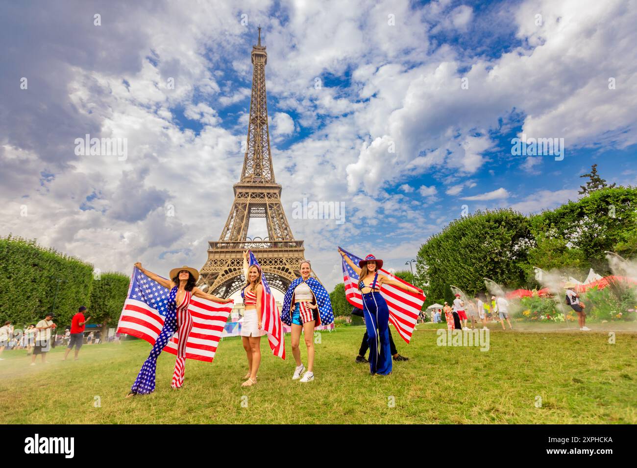Patriotic American Woman jumping and cheering for Team USA and the Paris 2024 Olympics in front ...