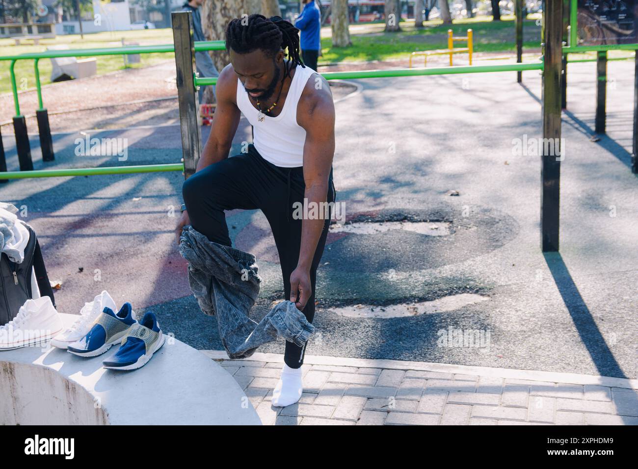 Young African Man with beard and dreadlocks, changing clothes in the ...