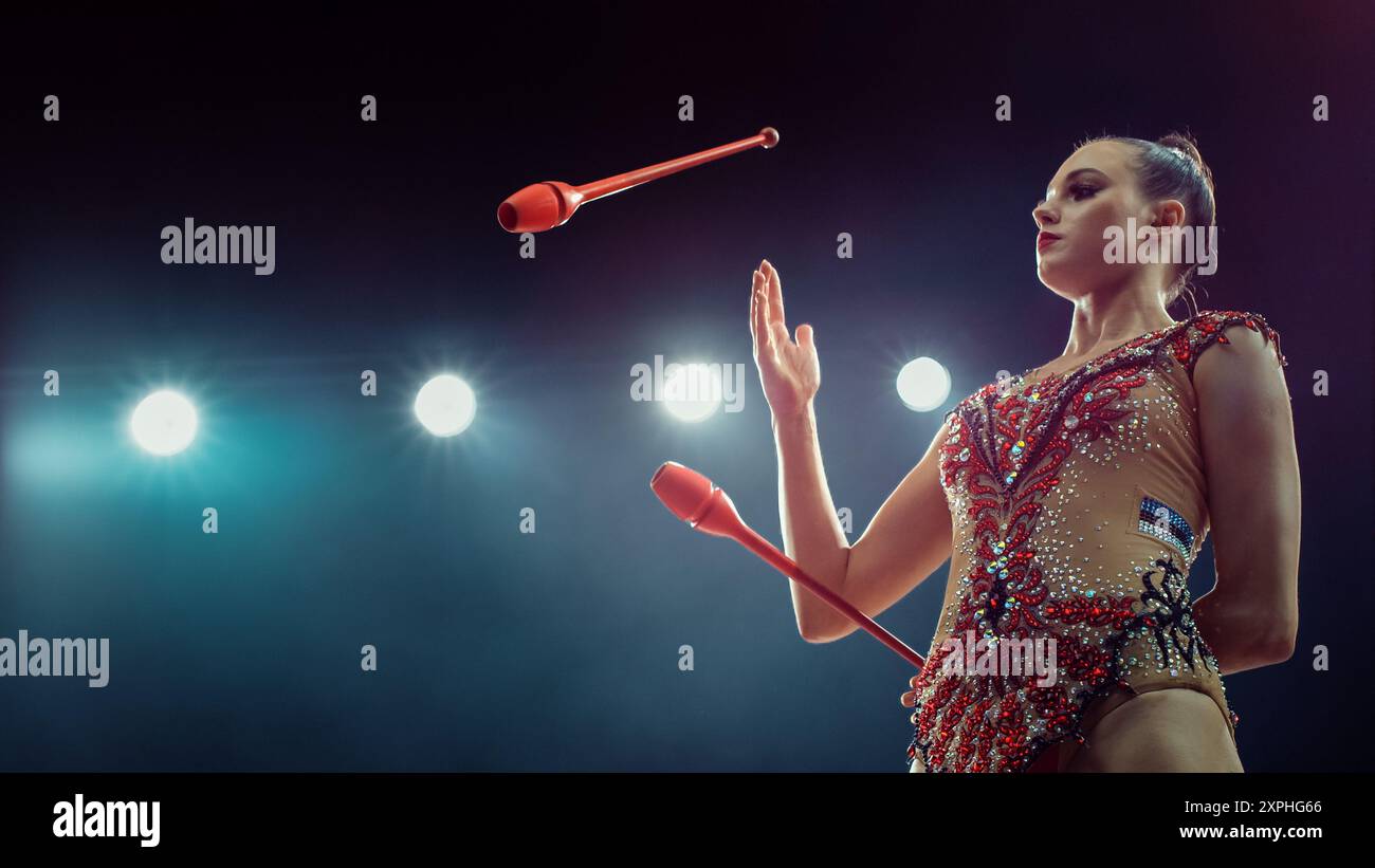 Caucasian Female Gymnast in Glittering Costume, Expertly Juggling Clubs ...
