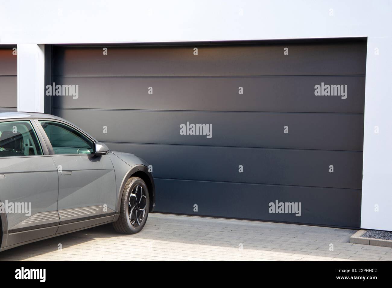 Modern garage door (sectional door) with car parked in front Stock ...