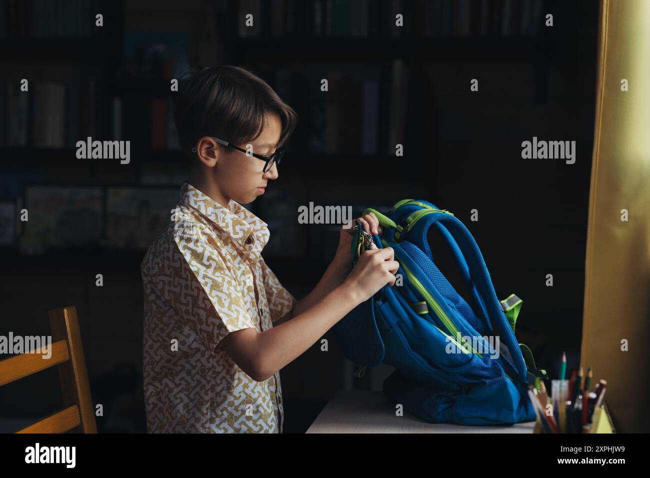 Student with glasses preparing for school and collecting stuff in his ...