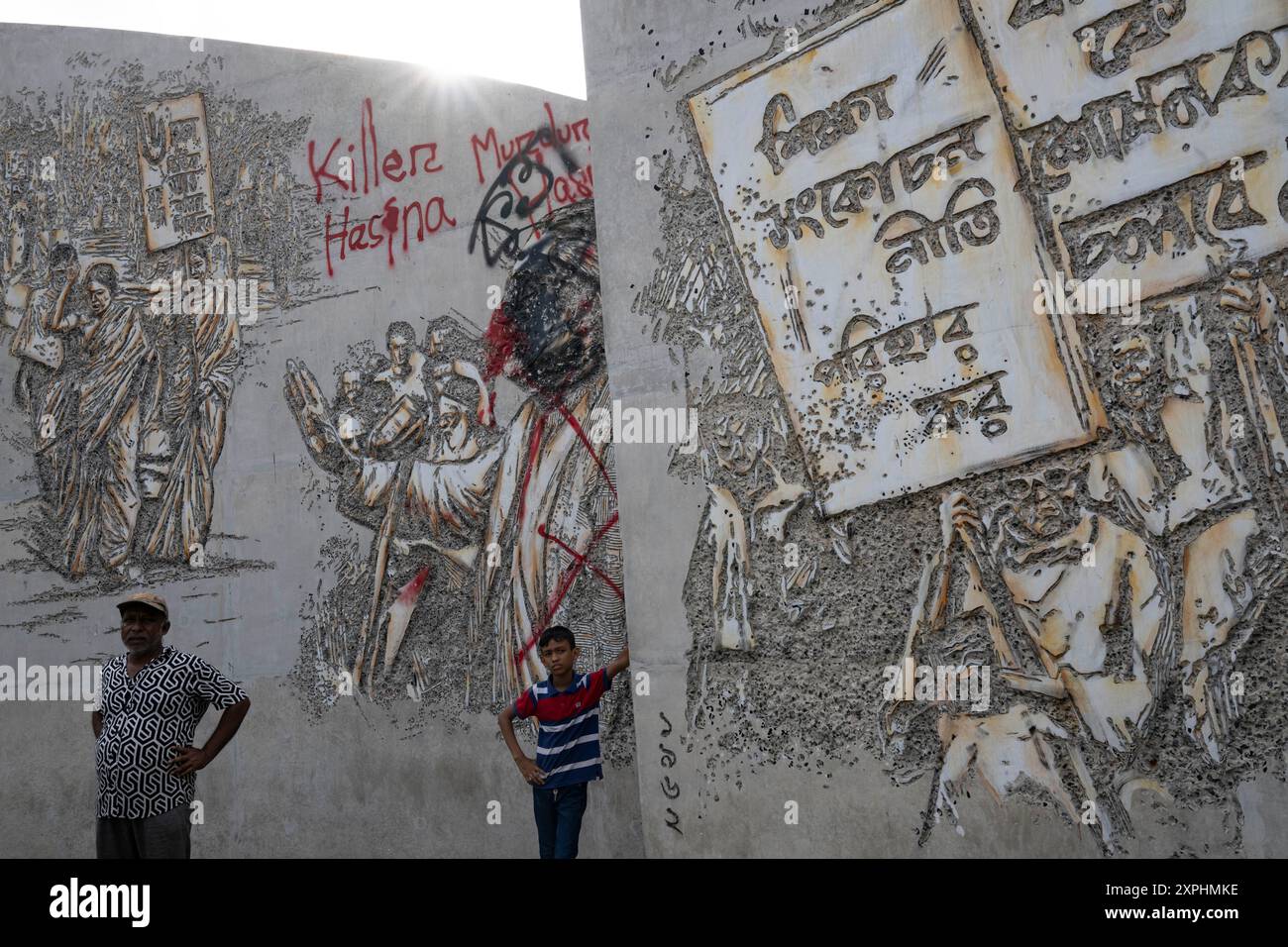 People stand near vandalised murals of Sheikh Mujibur Rahman, father of ...
