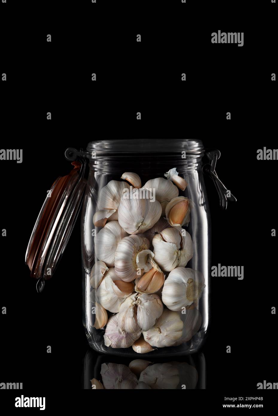 Garlic Cloves in a glass storage or canning jar isolated on black with ...