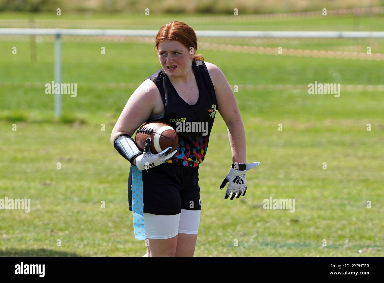 A female flag football holds the football Stock Photo - Alamy