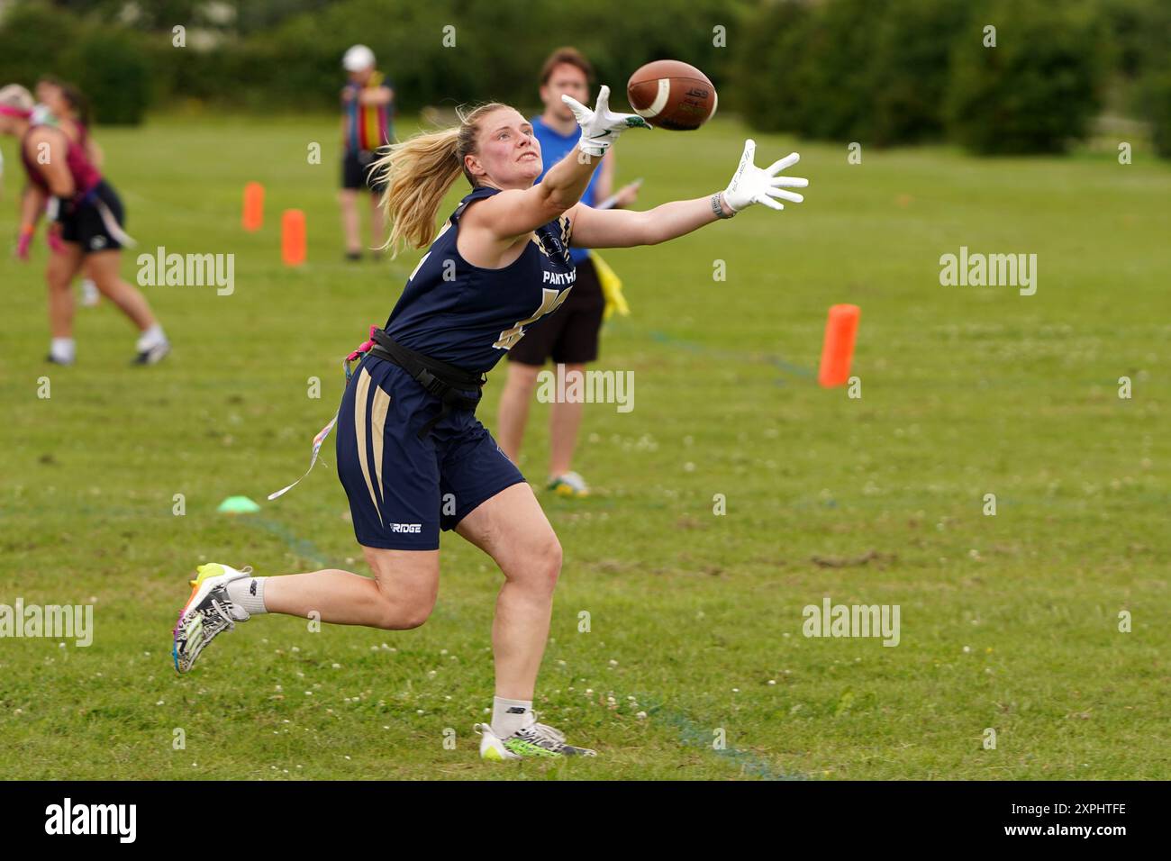 a female flag football player stretches to reach the ball Stock Photo ...