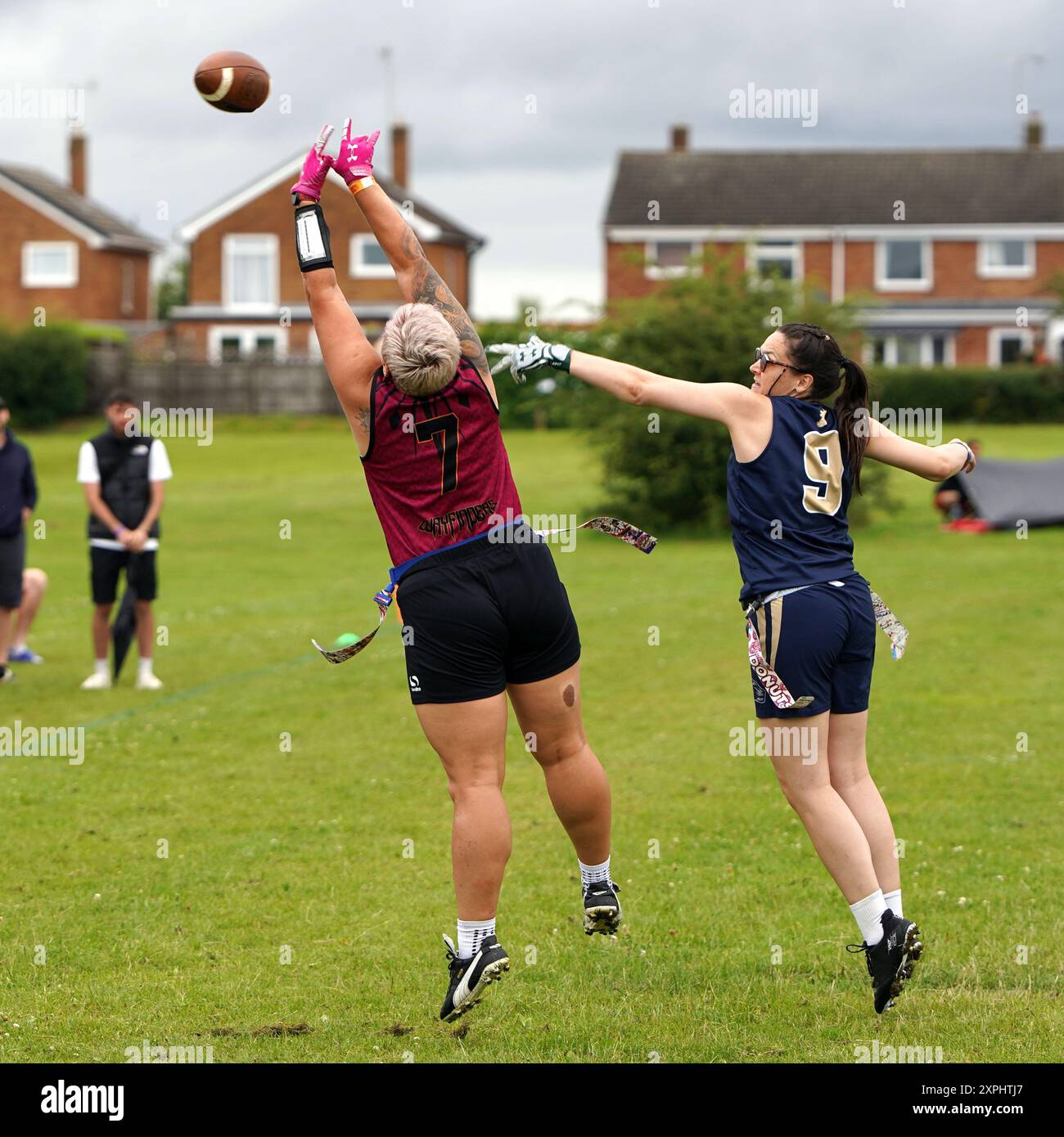 two female flag football players compete for the ball in the air Stock ...