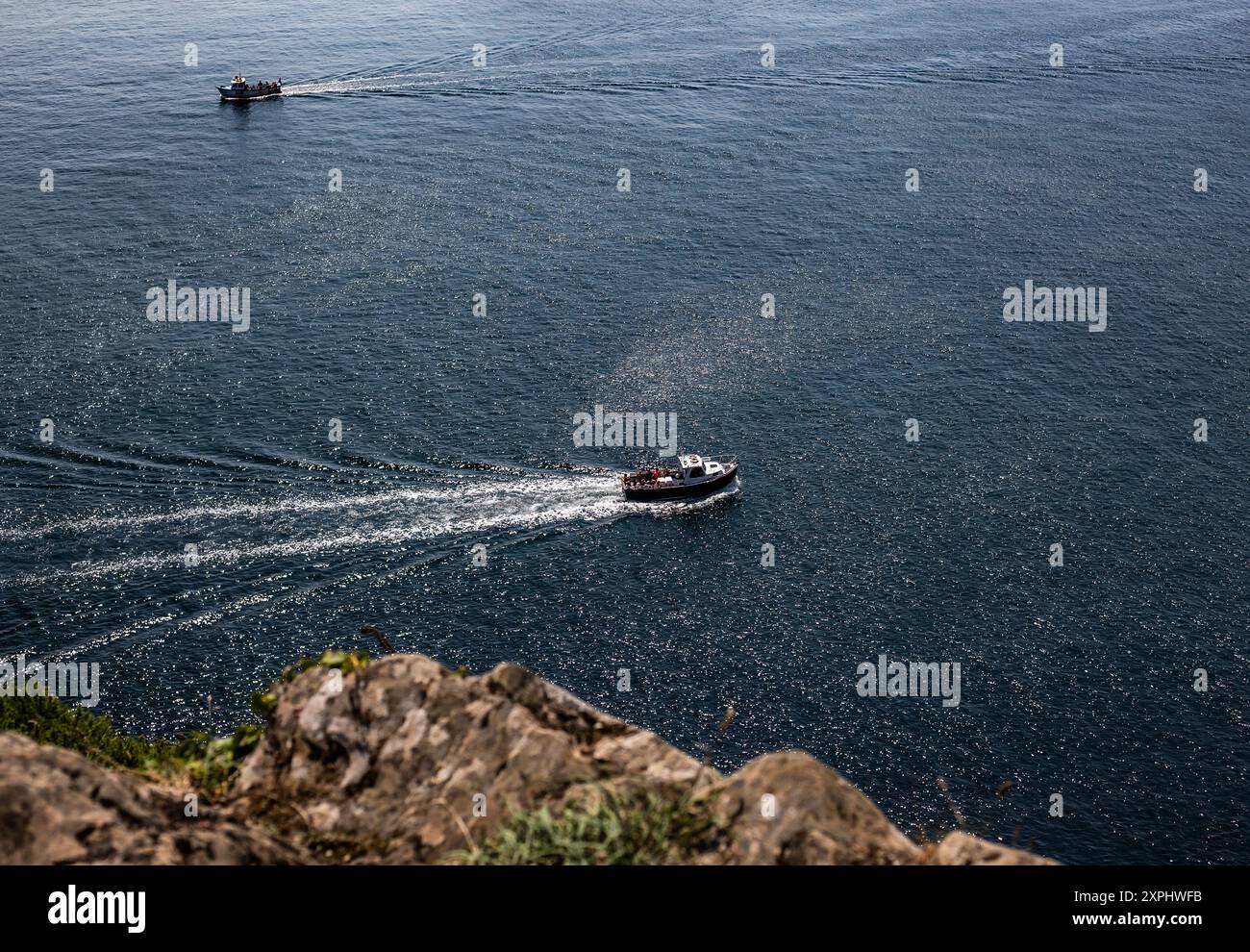 Small pleasure boats leaving Polperro leaving a trail of white water in ...