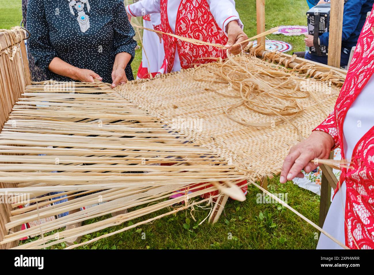 Hands of senior women weave bast cloth on wooden loom at Siberian Tatar ...