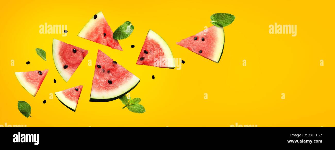 Pieces of ripe watermelon scatter in different directions on a orange ...