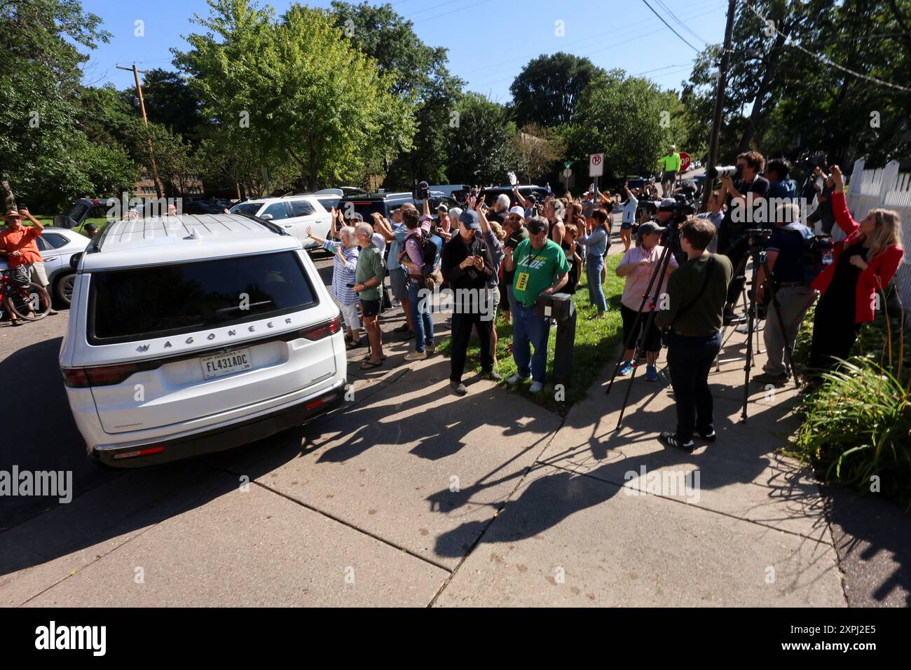 Cars carrying Minnesota Gov. Tim Walz drive past cameras and crowds in ...
