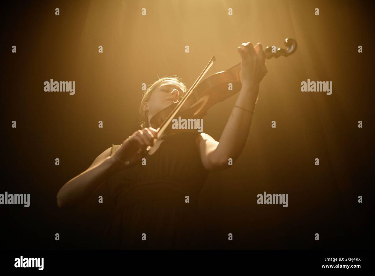 Low angle shot of female classical music artist sensually playing ...
