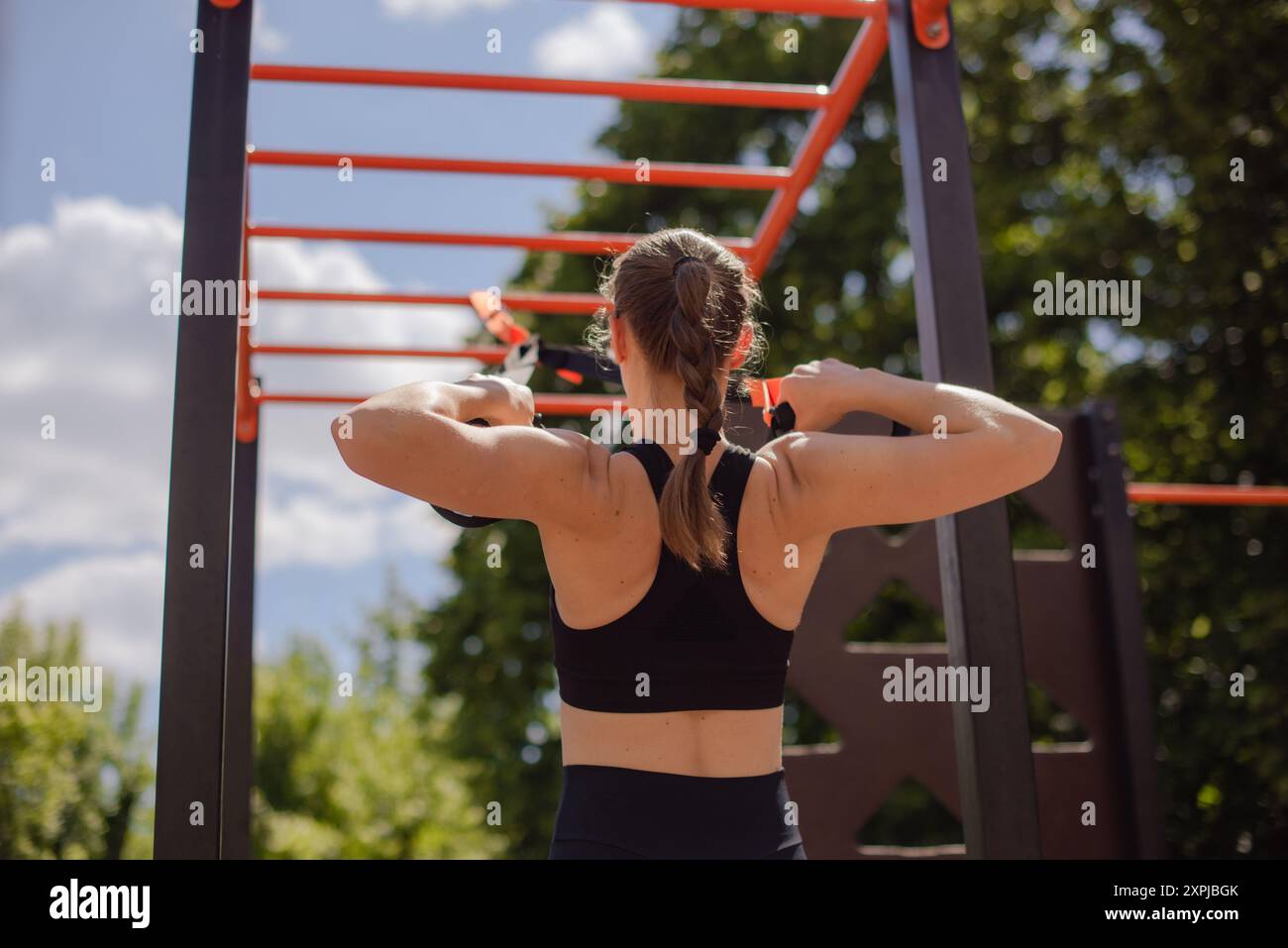 woman doing TRX training at open air gym. Outdoor fitness background ...