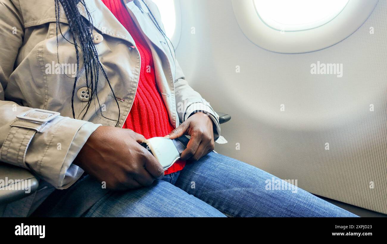 Woman buckling seatbelt on airplane hi-res stock photography and images ...