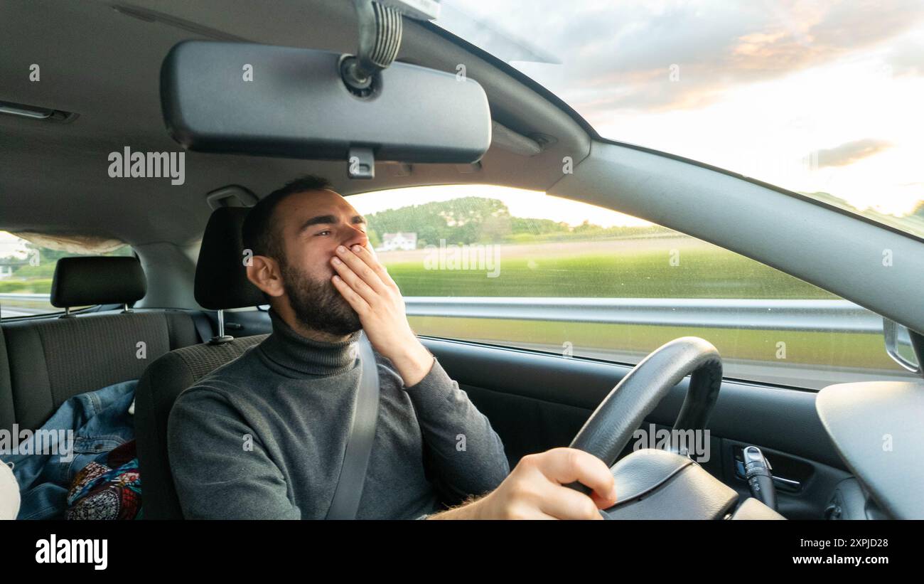Young driver tired and yawning Stock Photo - Alamy