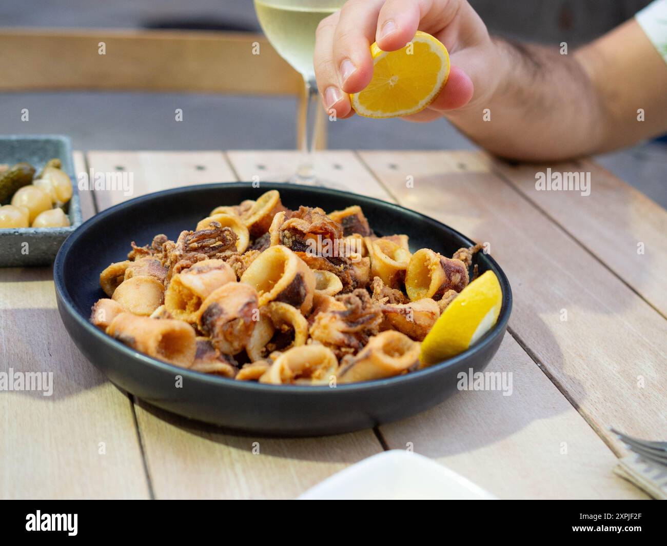 Hand squeezing lemon over fried hi-res stock photography and images - Alamy