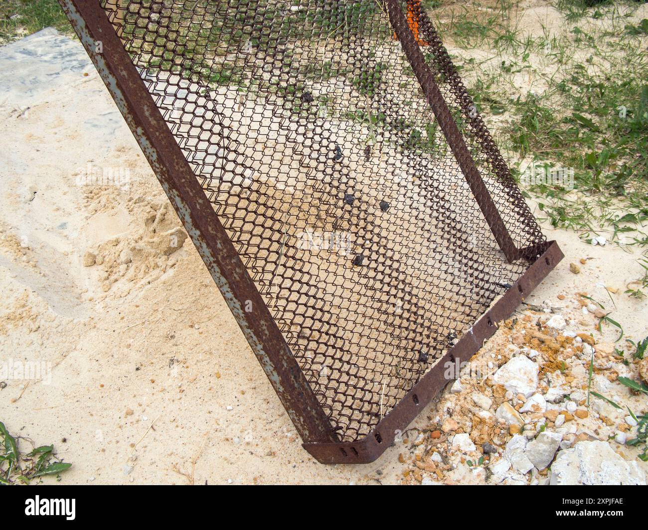 Sifting sand through the armored mesh of an old bed Stock Photo - Alamy