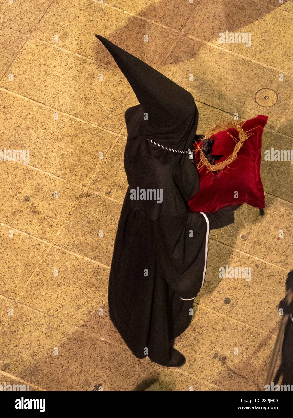 Hooded man carrying Jesus crown of thorns during Holy burial procession ...