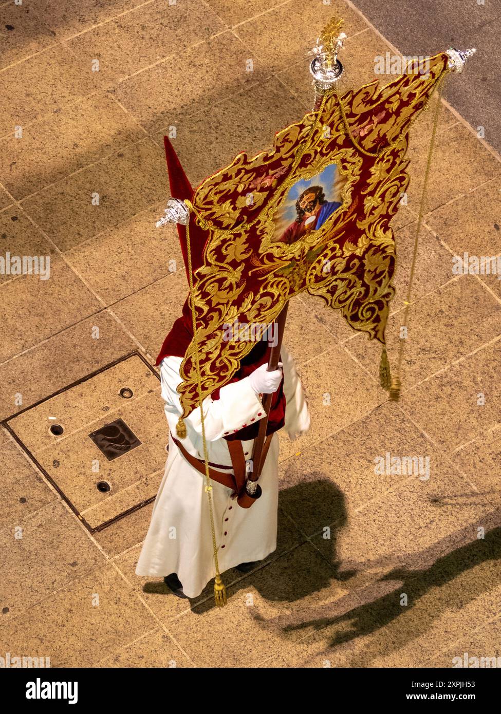 Hooded man carrying a religious banner on Holy burial procession ...