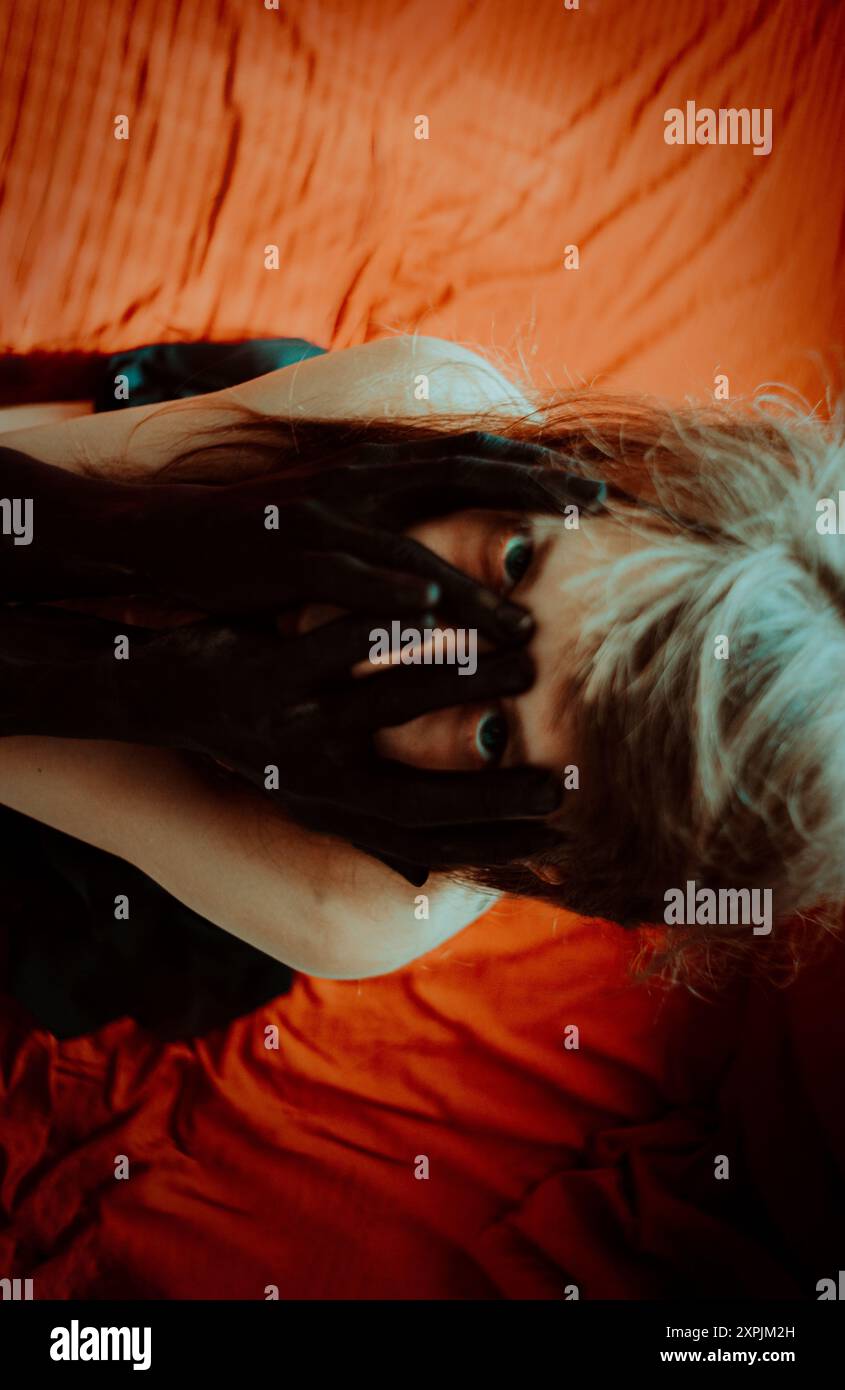 There is a cursed figure on a red background, covering its face with ...