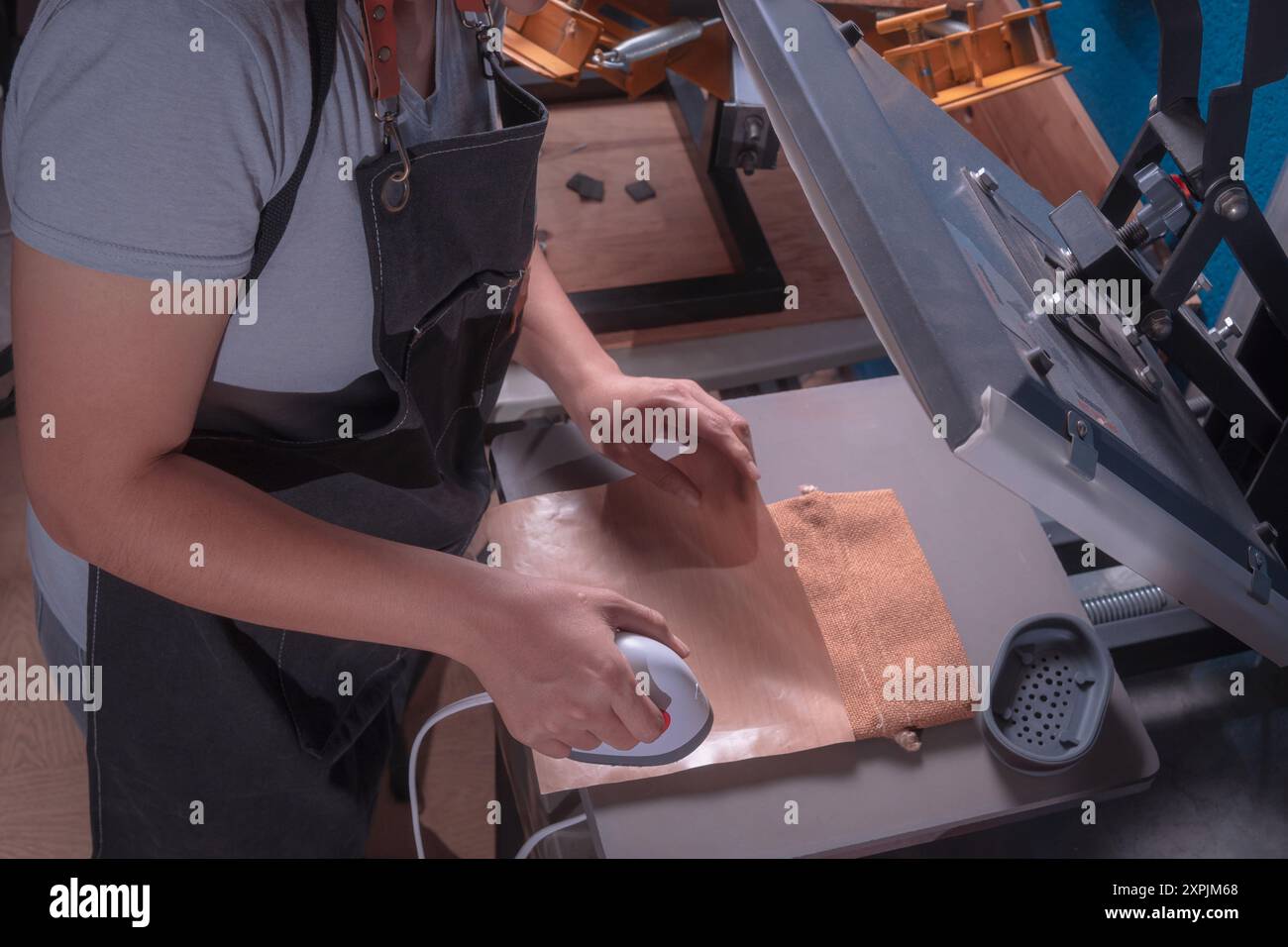 Young working woman in her workshop makes the sublimation process with ...