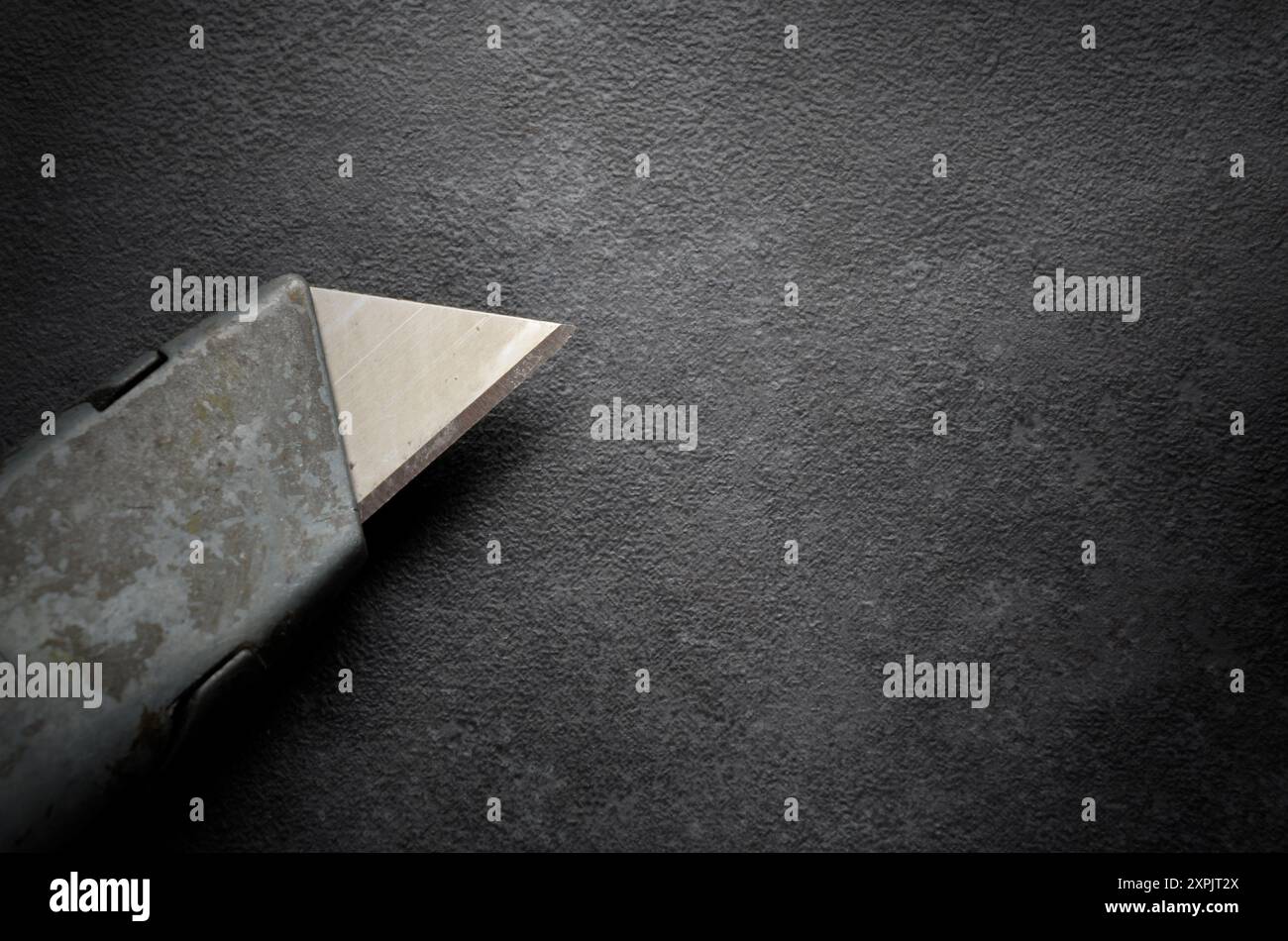 Close up of old used metal utility knife showing the blade shot from ...