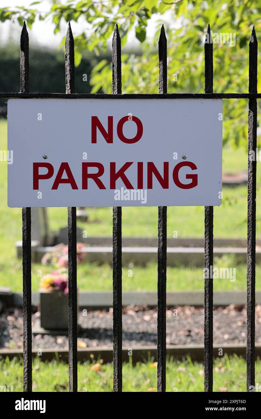 No parking sign attached to wrought iron railings outside cemetery in ...