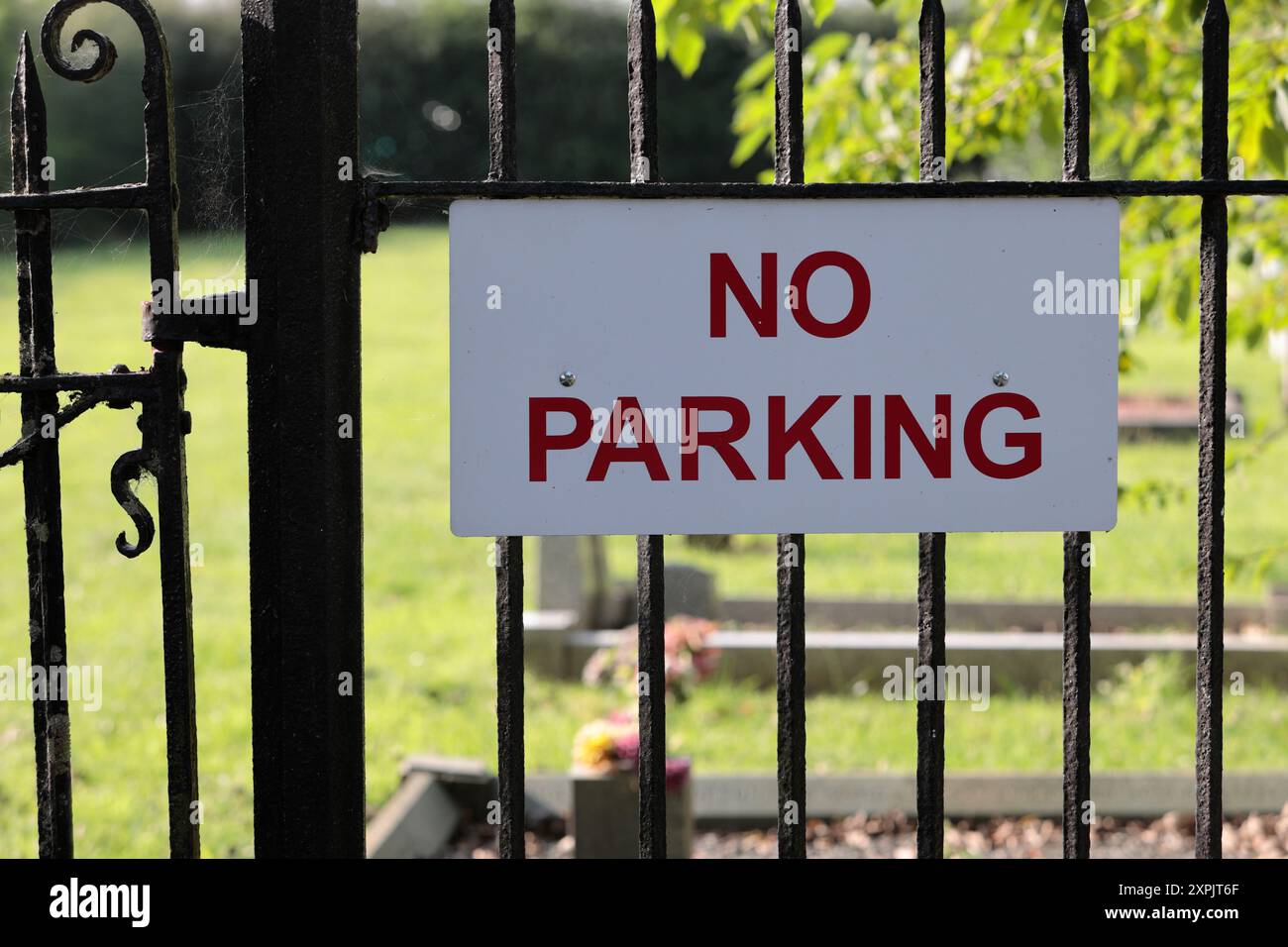 No parking sign attached to wrought iron railings outside cemetery in ...