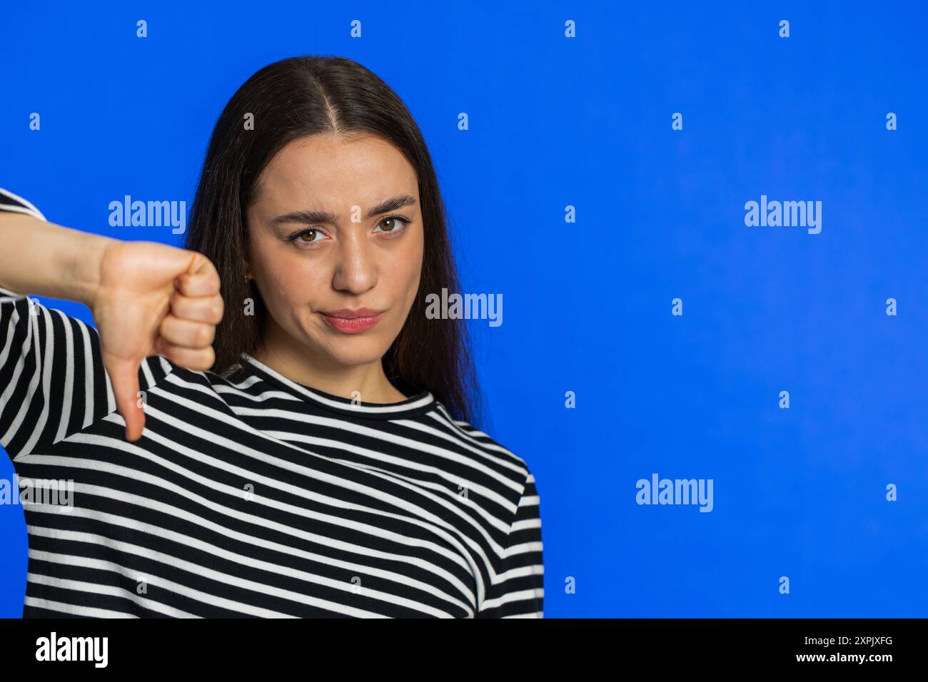 Dislike. Upset unhappy woman showing thumbs down sign gesture ...