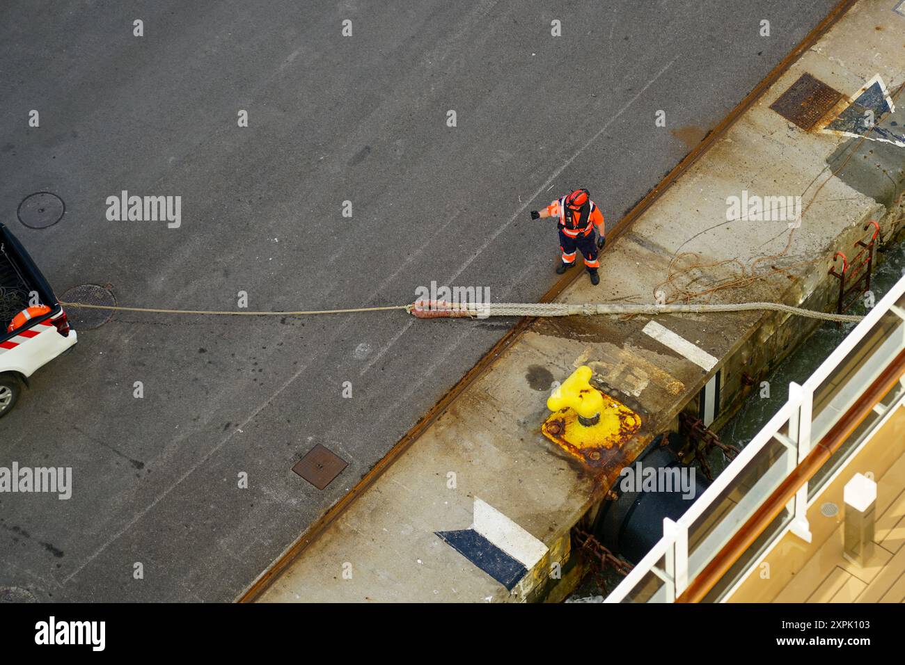 The process of mooring a large cruise ship with a rope at the harbor ...