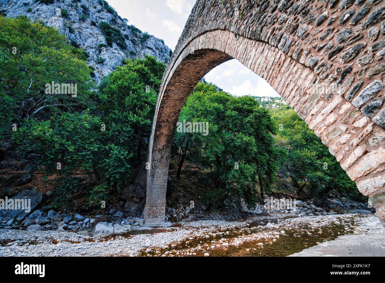 The old stone bridge in Pyli village, Thessaly, Greece, features a semi ...
