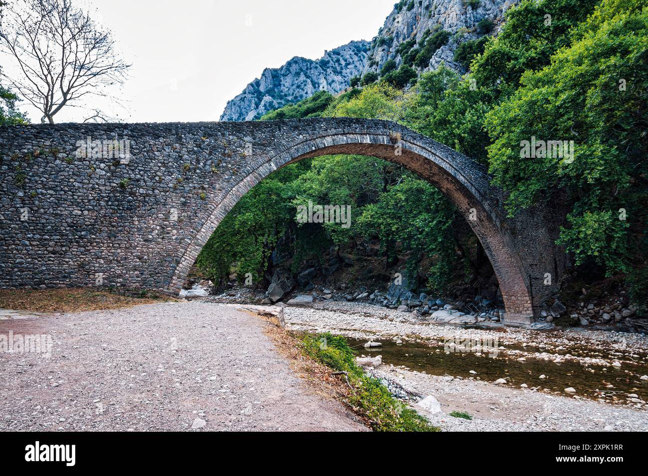 The old stone bridge in Pyli village, Thessaly, Greece, features a semi ...