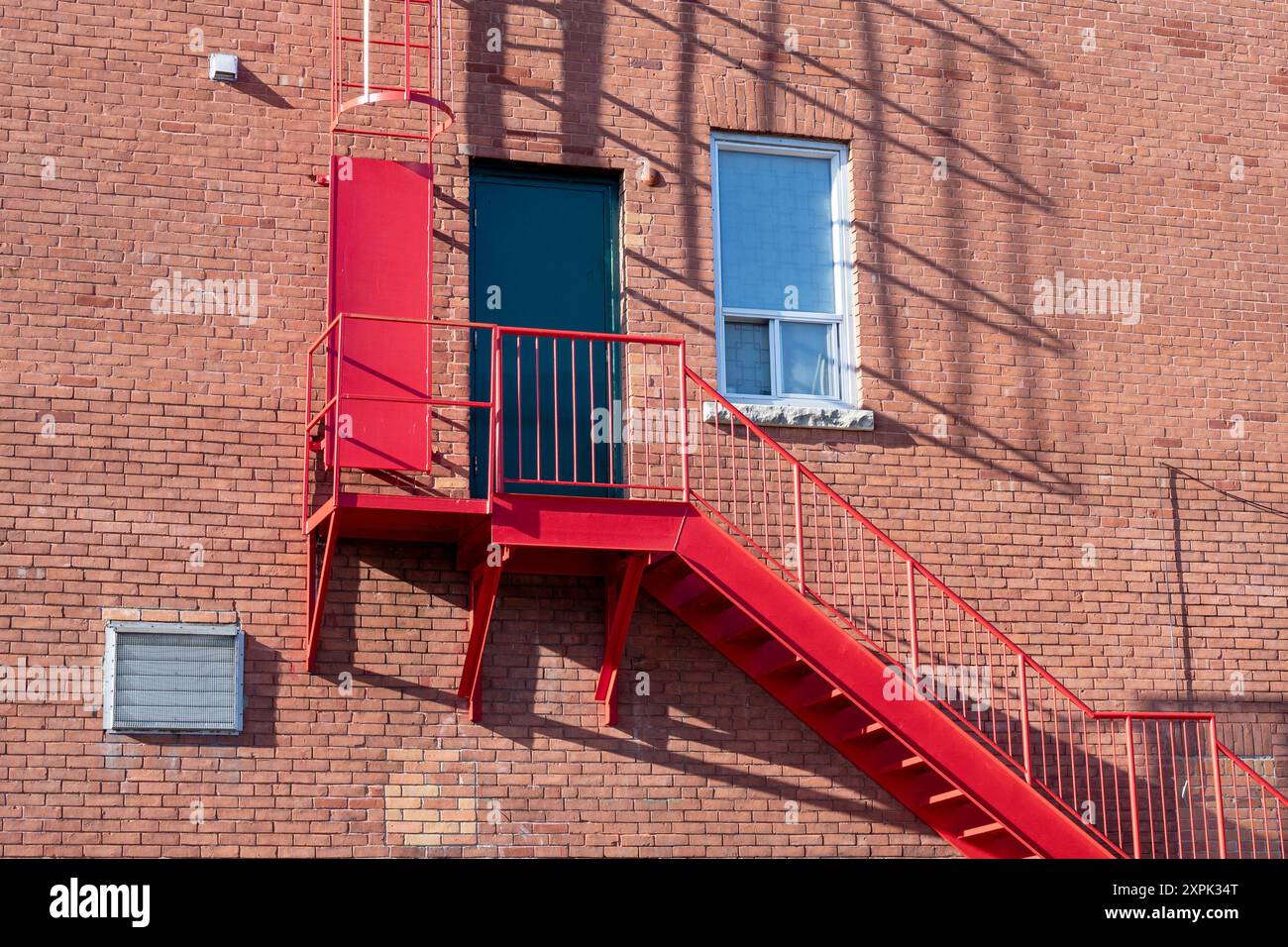 Red metal stairs outside the building, fire escape Stock Photo - Alamy