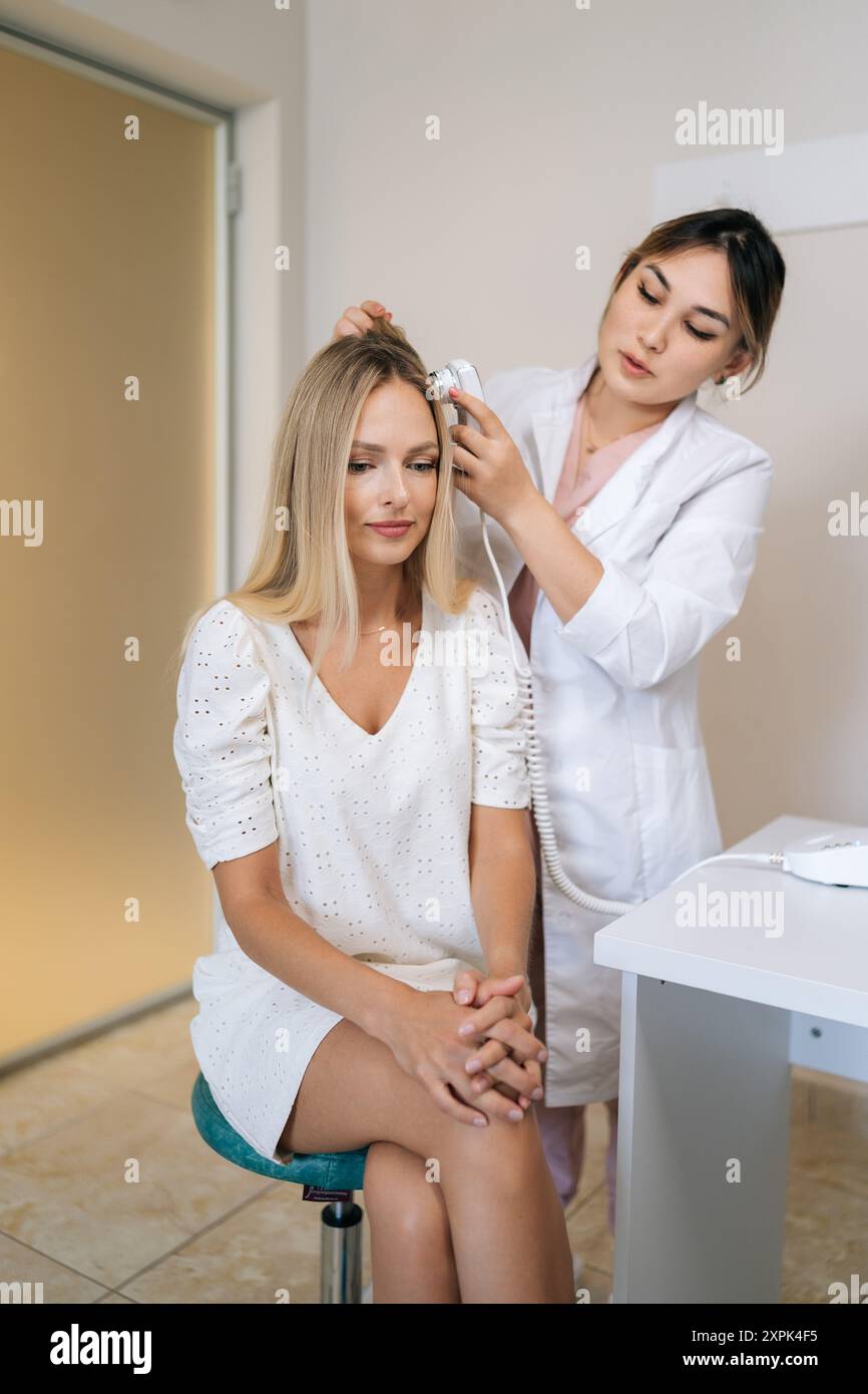 Vertical portrait of female trichologist making diagnosis of structure ...