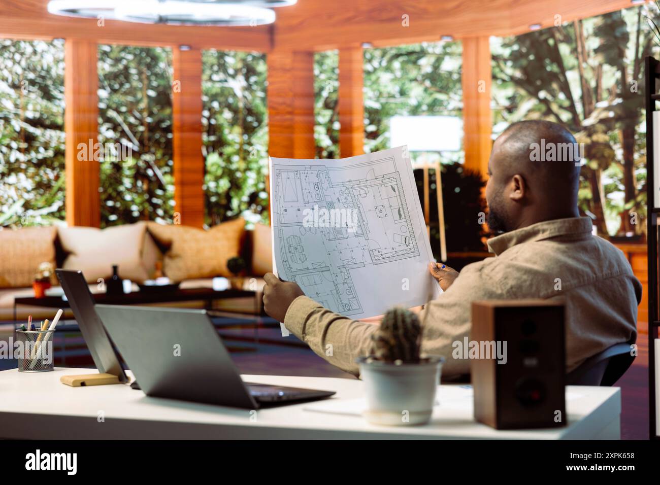 Businessman evaluating architectural sketches and planning an office ...