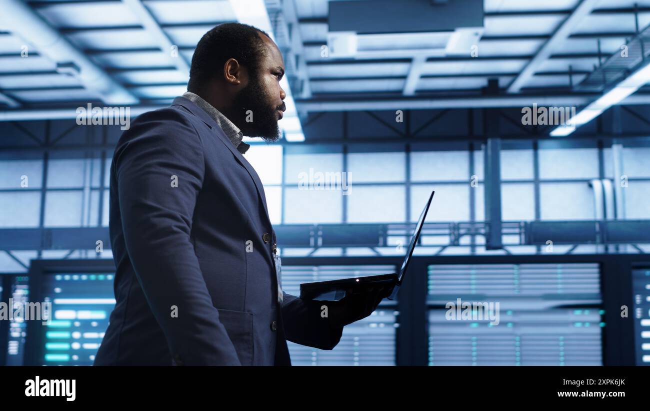 Admin doing yearly checkup using notebook to prolong data center electronics life span and avoid ...